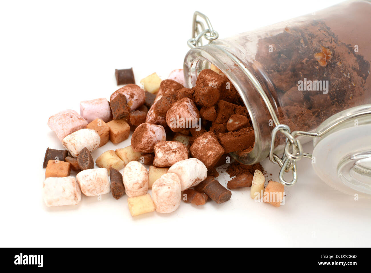 Marshmallows, fudge, chocolate, fudge and cocoa spill from a glass jar ...