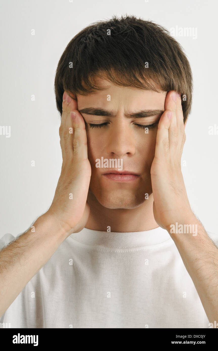 Young male adult, holding head in hands Stock Photo - Alamy
