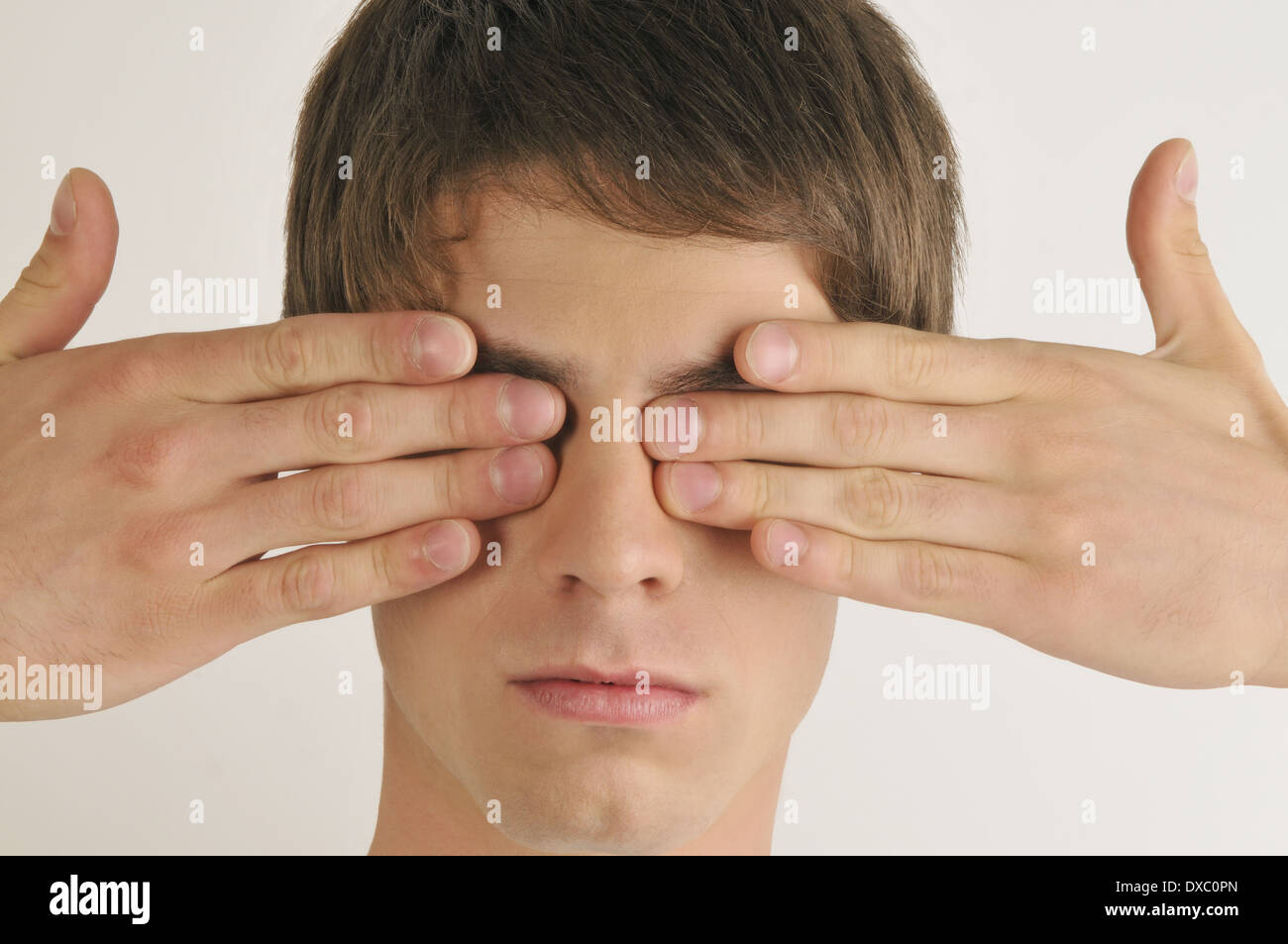 Young male adult, hands covering eyes Stock Photo - Alamy