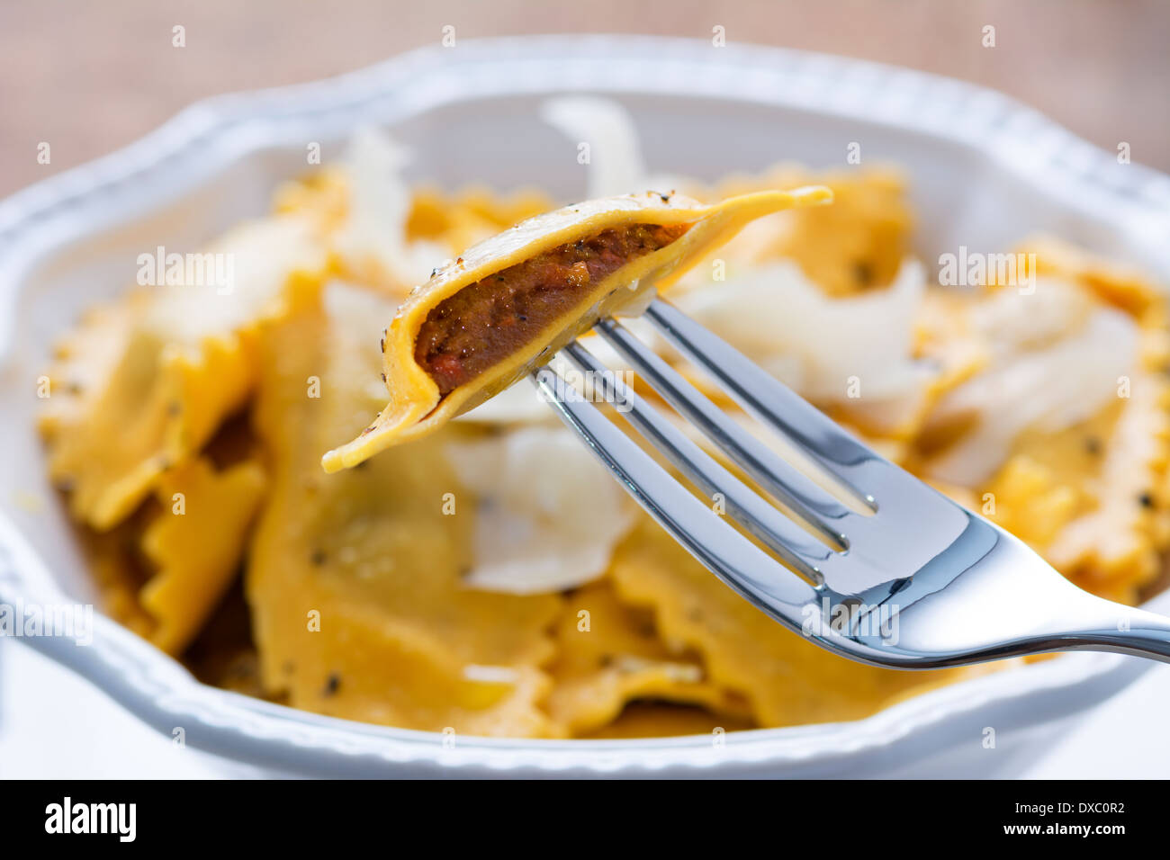 Butternut squash mezzaluna ravioli or tortellini cut in two on a fork ...