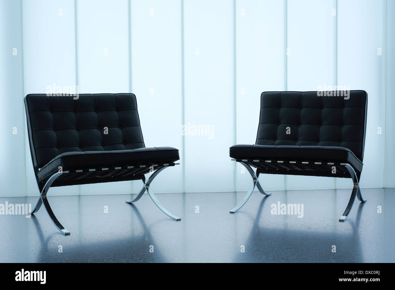 Photograph of two designer leather chairs lit by a mix of fluorescent ...