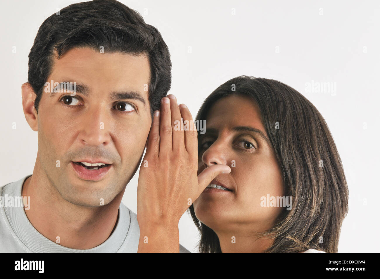 Female young adult whispering in man's ear Stock Photo - Alamy