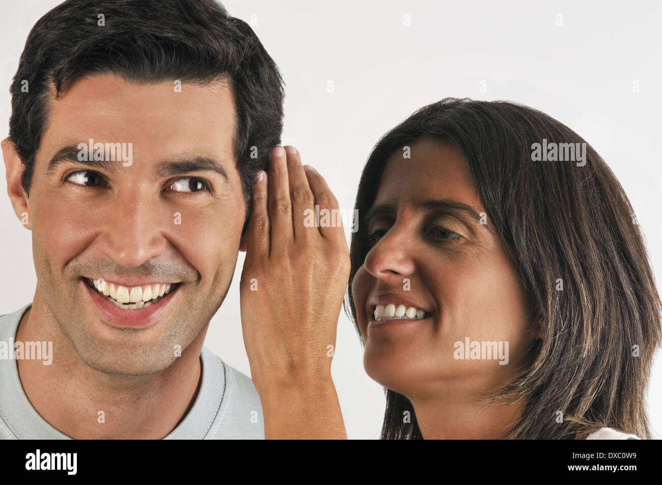 Female young adult whispering in man's ear Stock Photo - Alamy