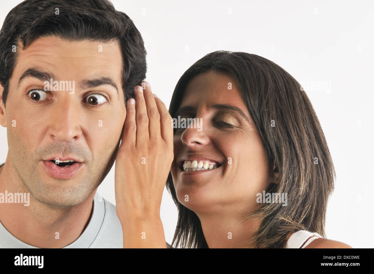 Female young adult whispering in man's ear Stock Photo - Alamy