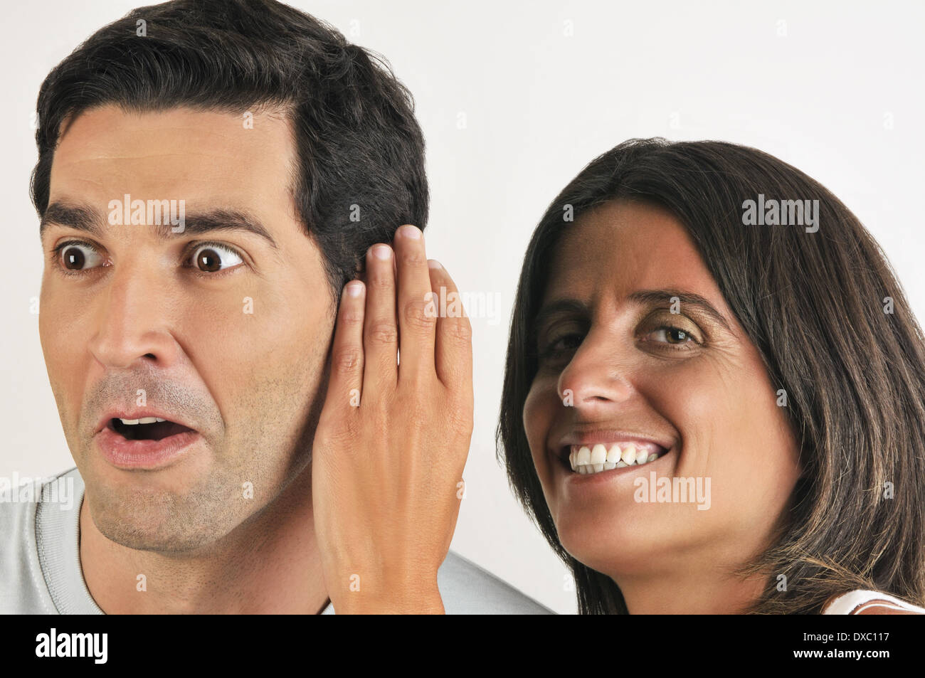Female young adult whispering in man's ear Stock Photo - Alamy