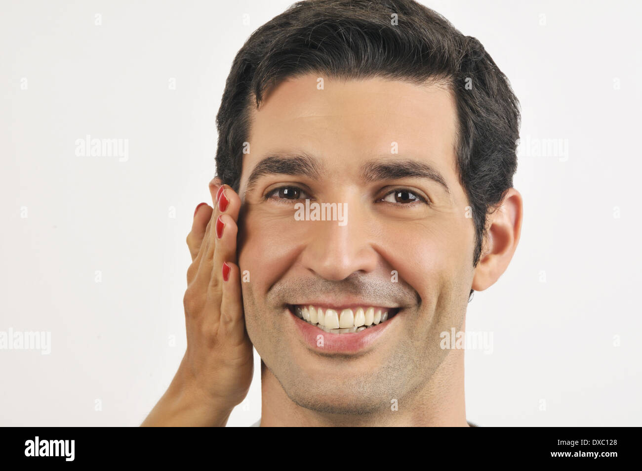 Female hand touching young adult male's cheek Stock Photo - Alamy