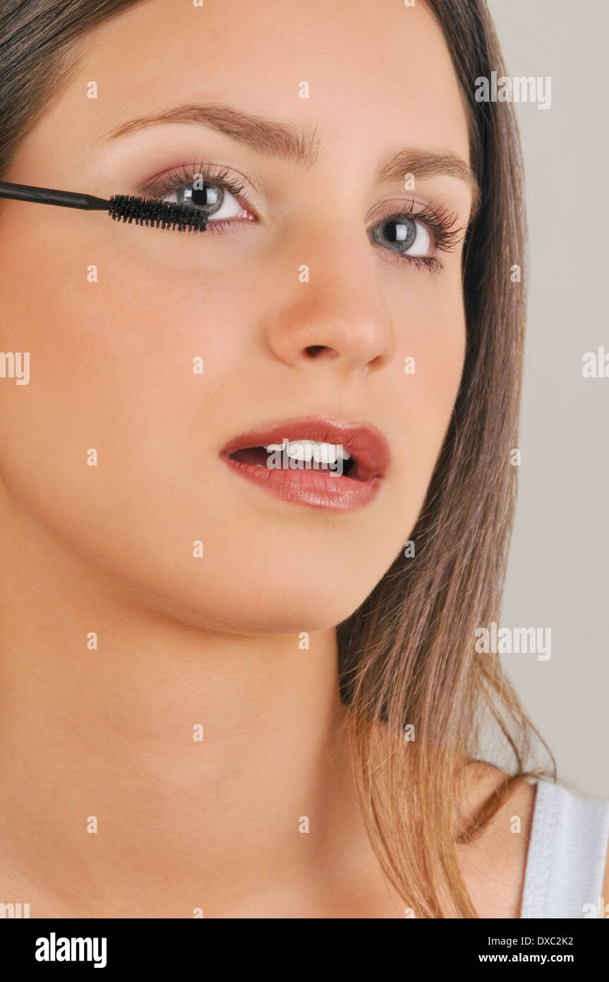 Female young adult applying mascara Stock Photo - Alamy