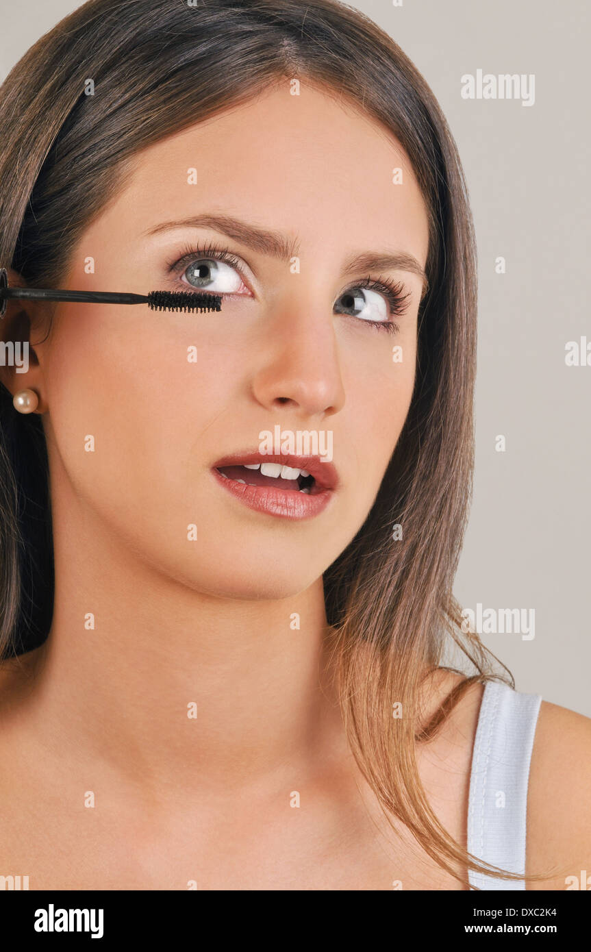 Female young adult applying mascara Stock Photo - Alamy