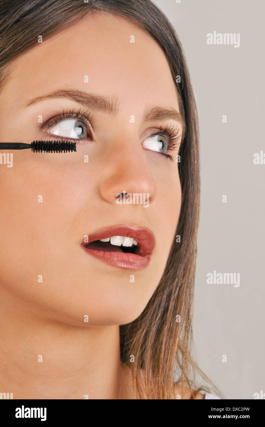 Female young adult applying mascara Stock Photo - Alamy