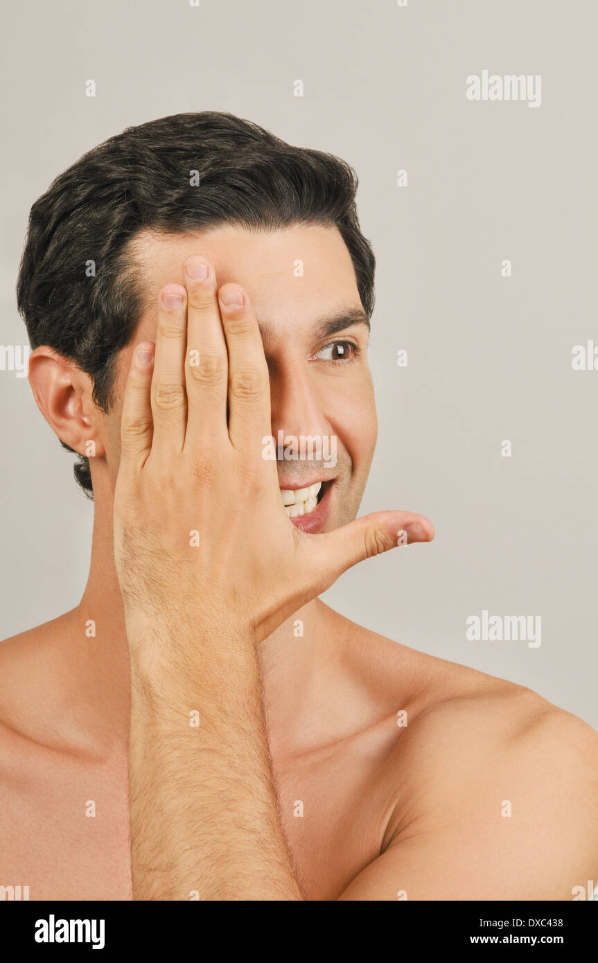 Young male adult, hand covering one eye Stock Photo - Alamy
