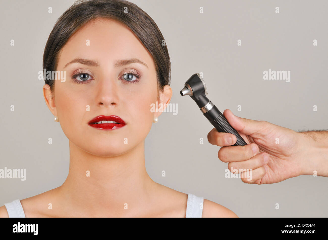 Female young adult and doctor's hand holding otoscope Stock Photo - Alamy