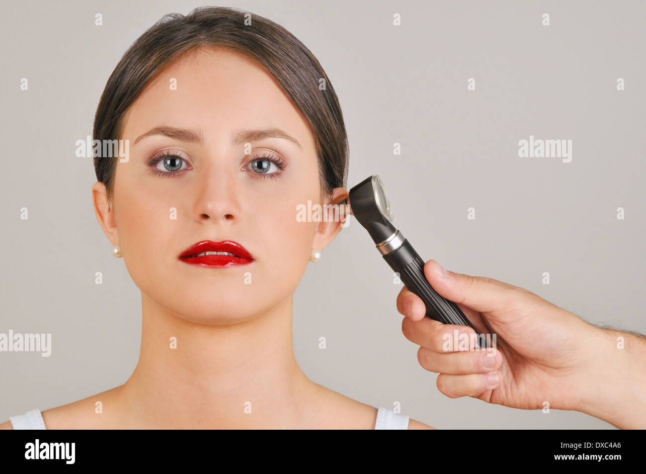 Female young adult and doctor's hand holding otoscope Stock Photo - Alamy