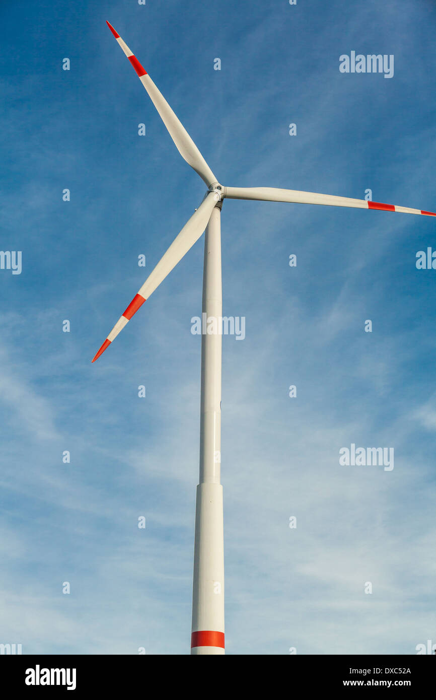 Wind turbine against a blue hazy sky in a conceptual image of renewable ...