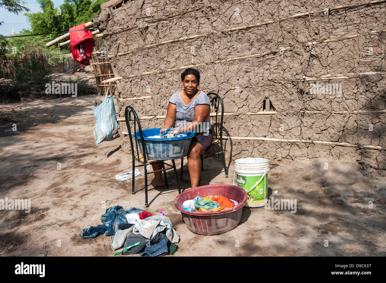 Afro-Peruvian woman washing clothes in her home, village of Yapatera ...