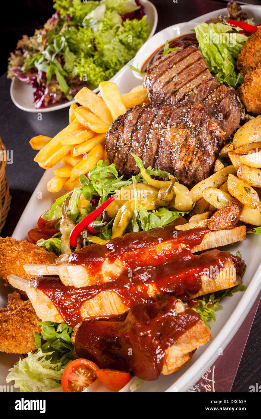 Wholesome platter of mixed meats including grilled steak, crispy ...