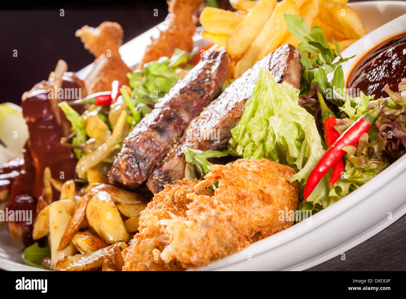 Wholesome platter of mixed meats including grilled steak, crispy ...