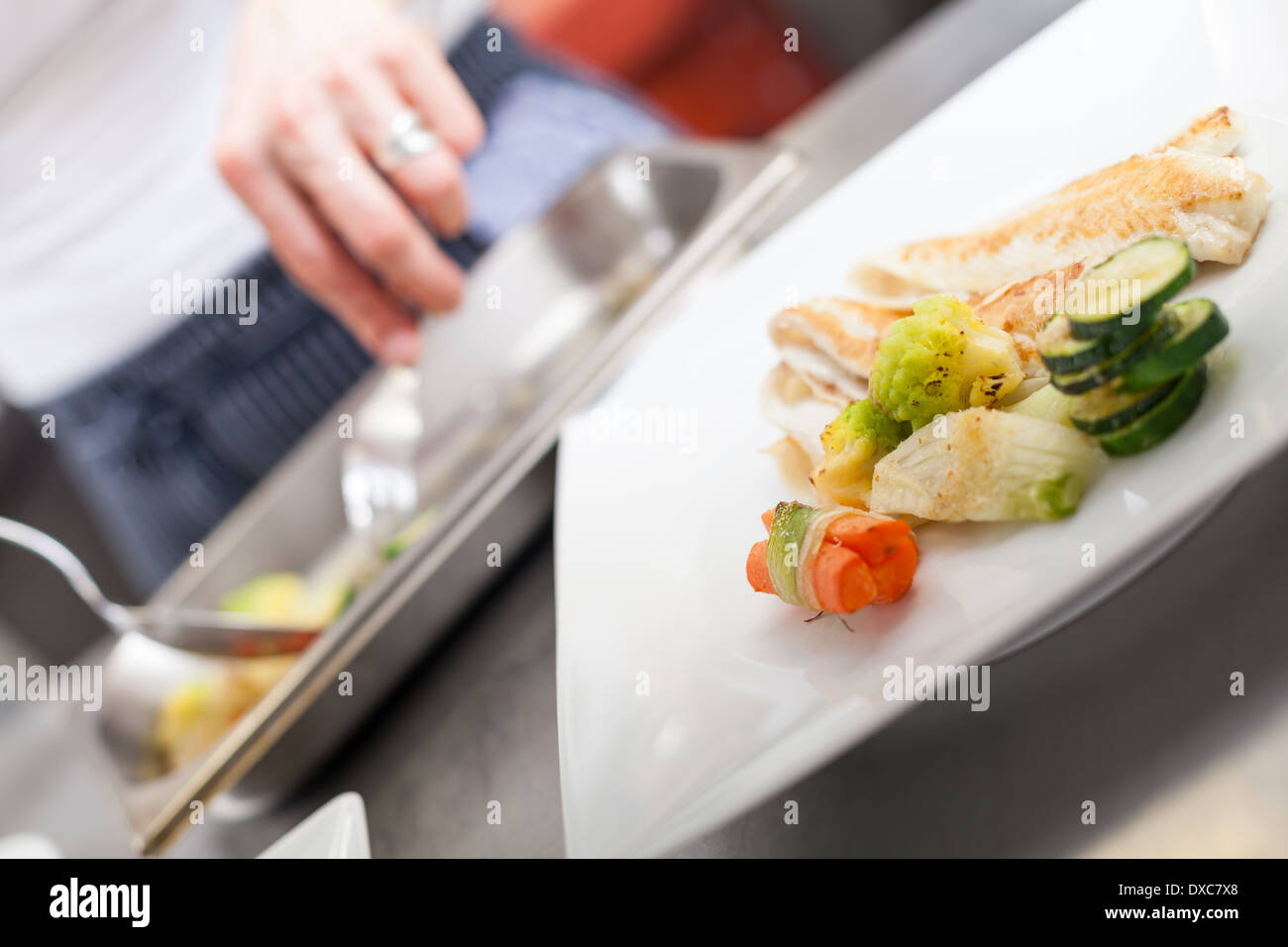 Fried fish fillets and vegetable garnish on a plate in a restaurant ...