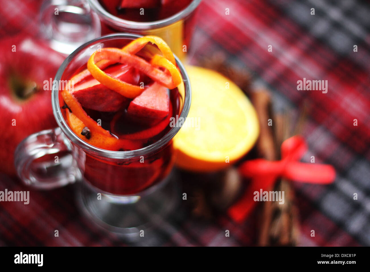 Hot red mulled wine with fruits and cinnamon on checkered tablecloth ...
