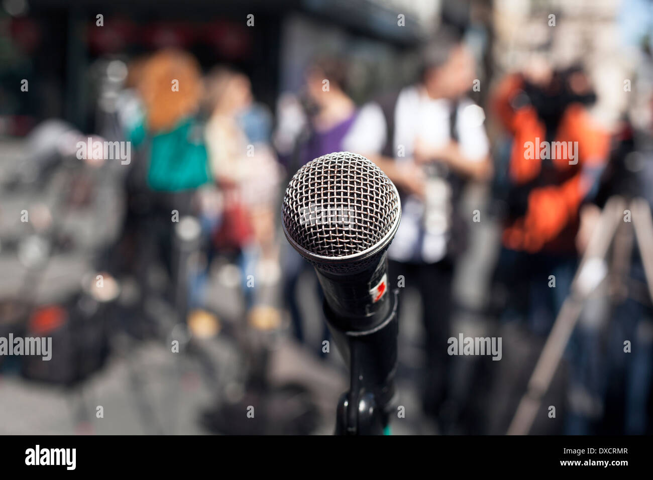 microphone in focus against blurred audience Stock Photo - Alamy