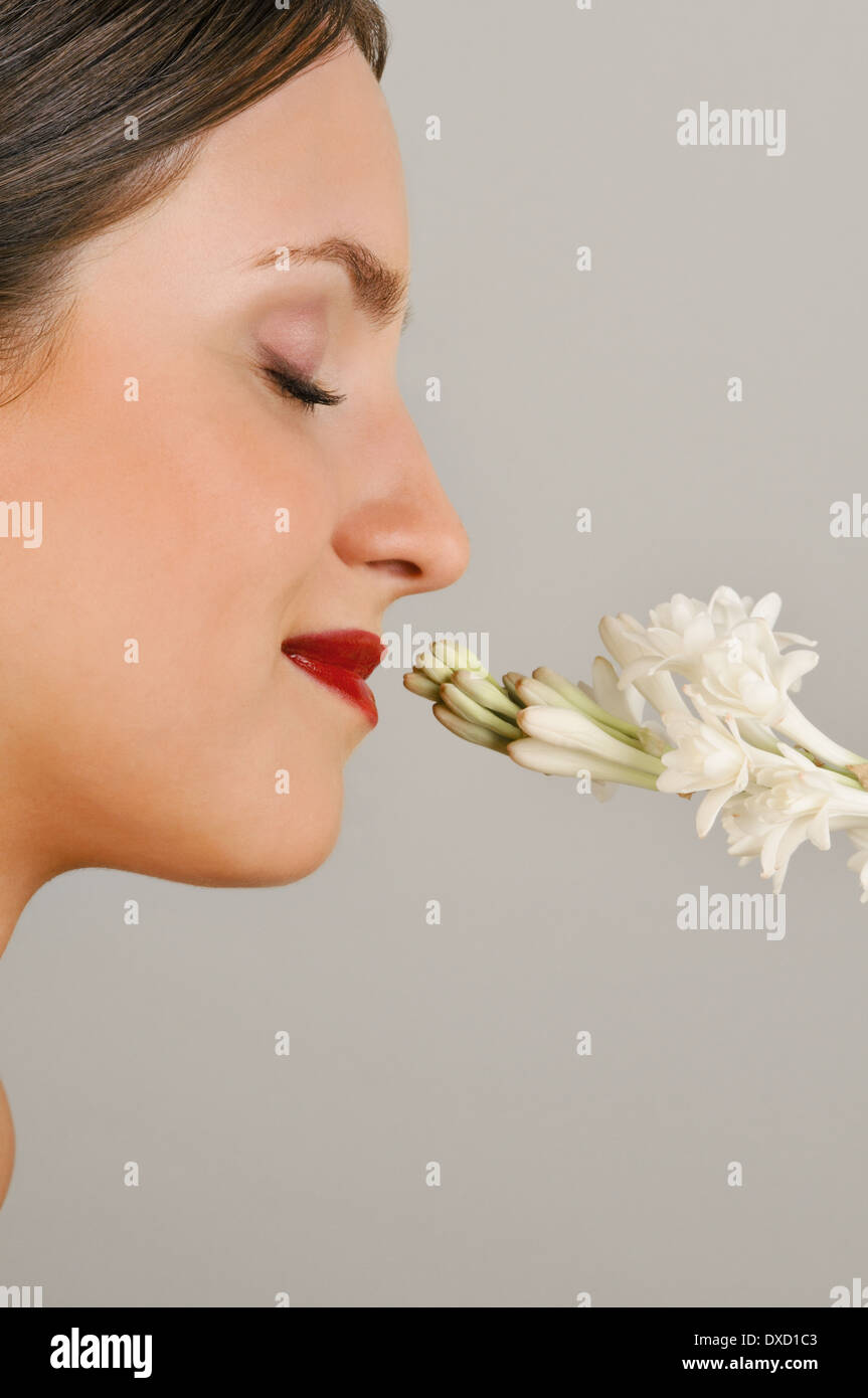 Female young adult smelling a flower Stock Photo - Alamy