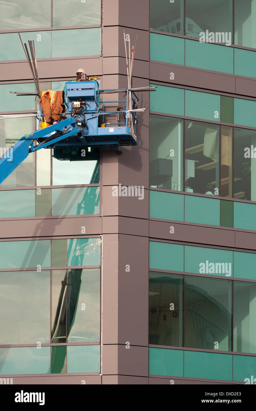 Office building construction worker installing window at Dartmouth ...