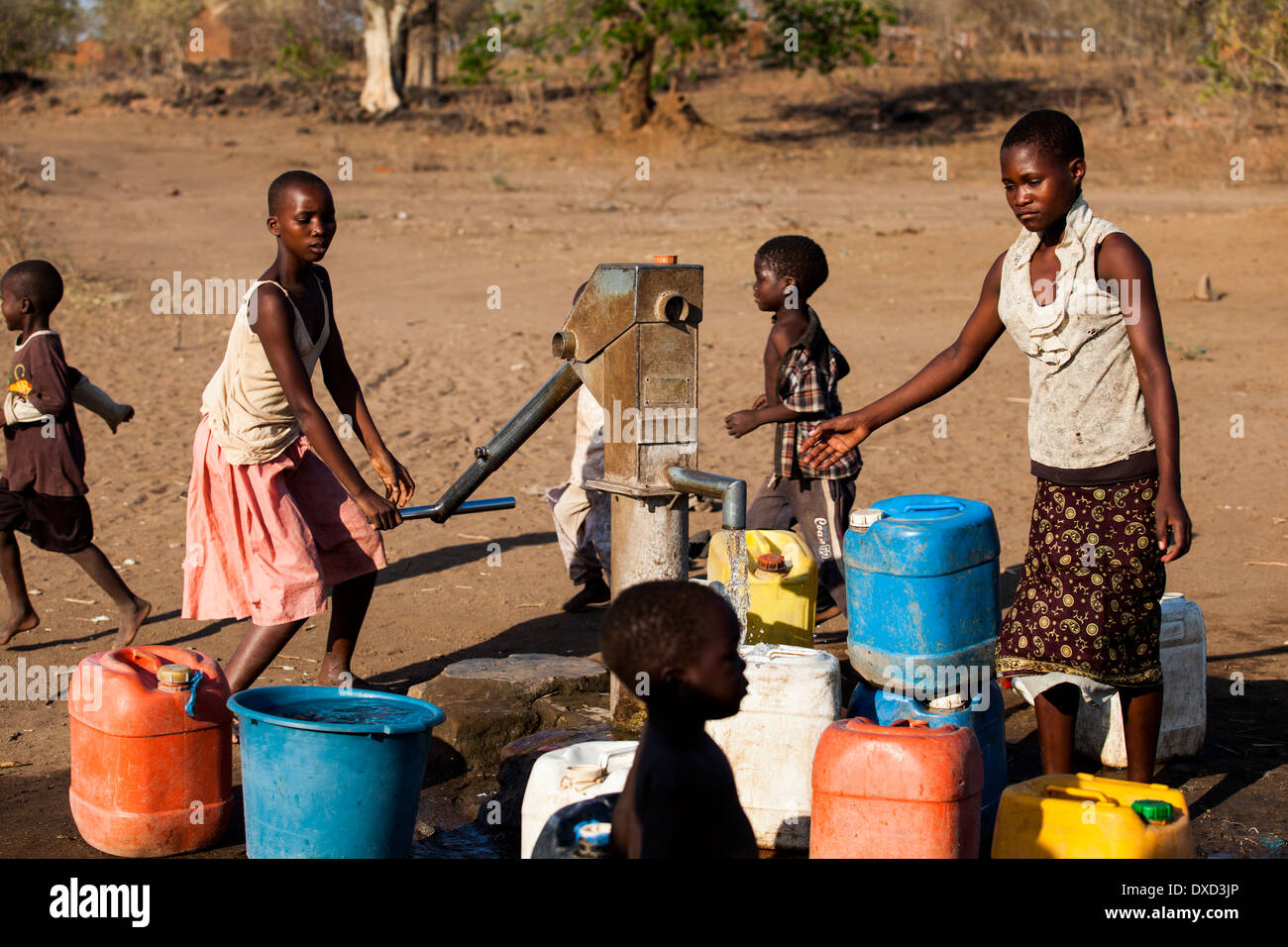 Africa children pumping water at a stand pipe Stock Photo - Alamy