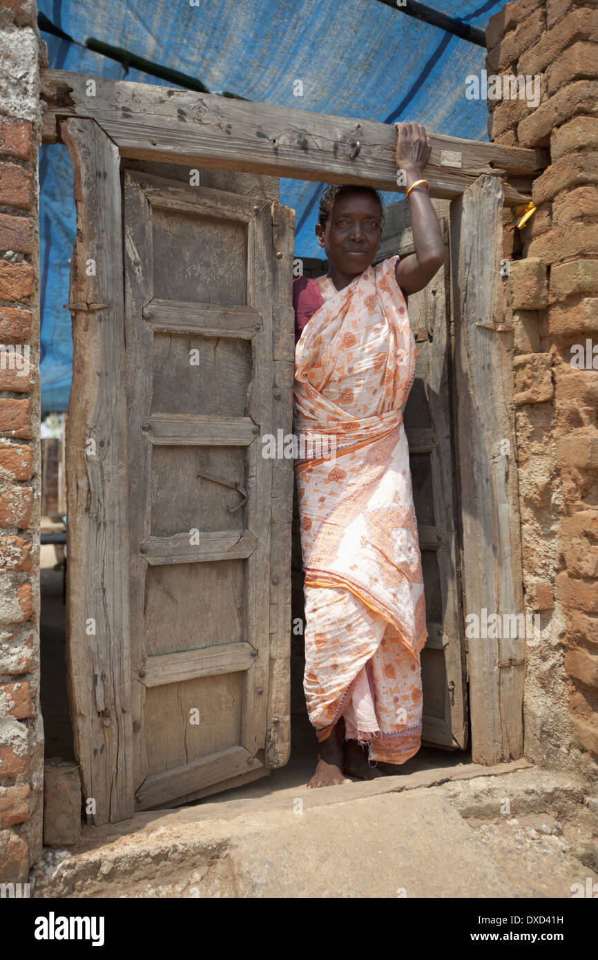 Portrait of a tribal woman standing at the door of her house. Murmu ...
