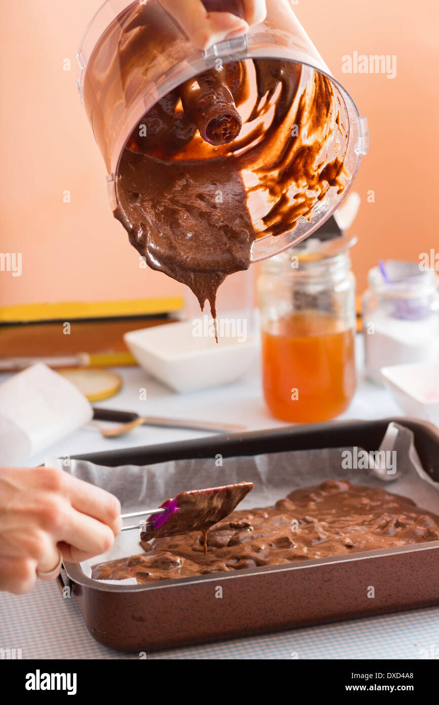 Chef pouring cake batter in a baking tin, close up Stock Photo - Alamy