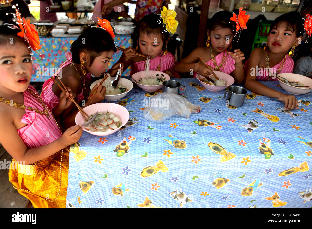 Female children eat noodles prior to an event in Chainat, Thailand ...