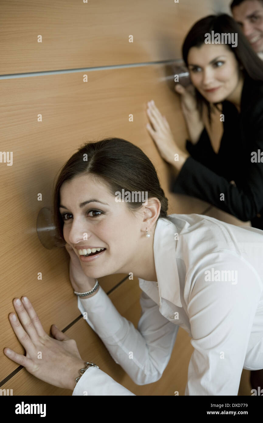 Office workers eavesdropping against wall Stock Photo - Alamy