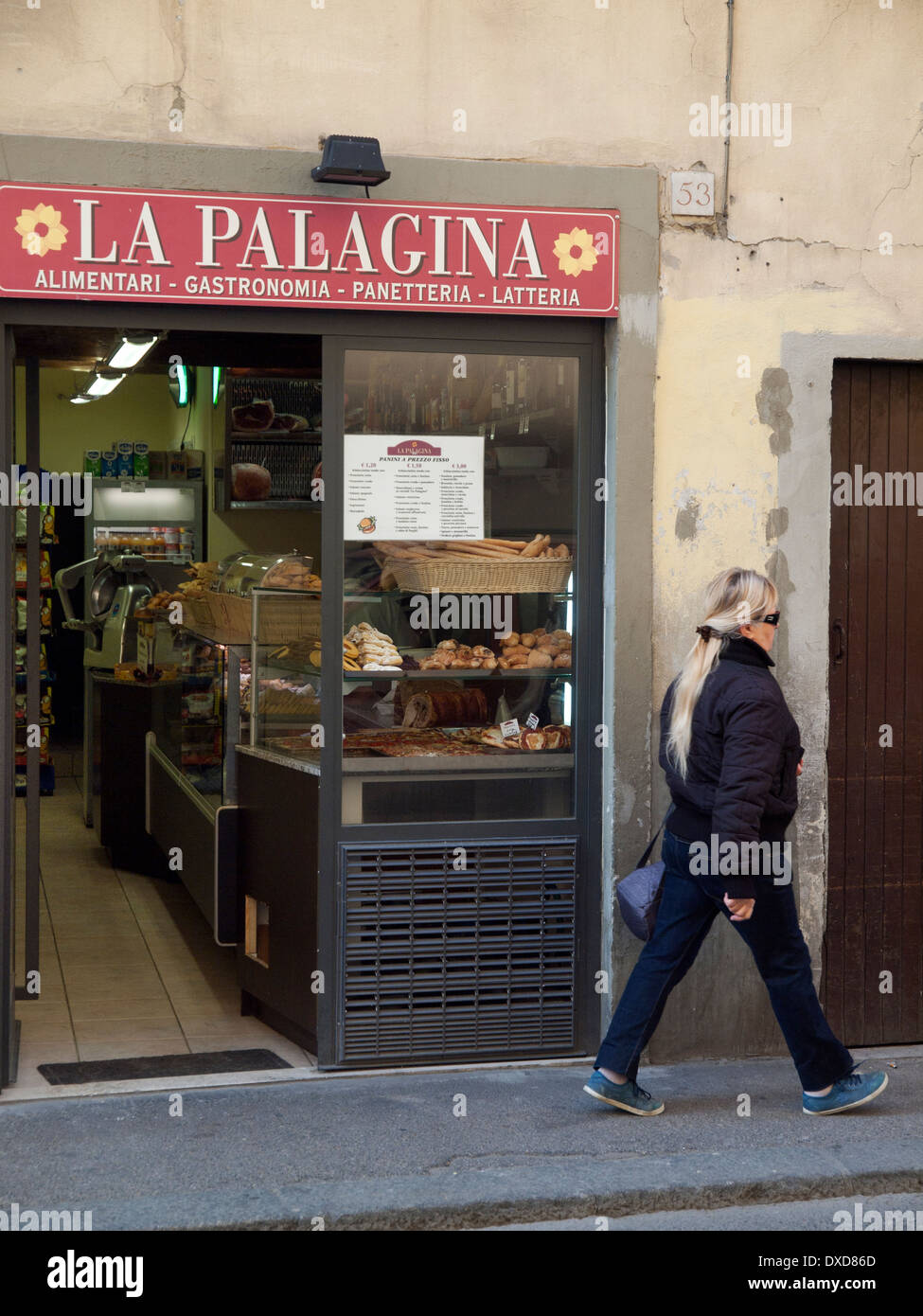 A woman walks past a small bakery in Florence Stock Photo - Alamy