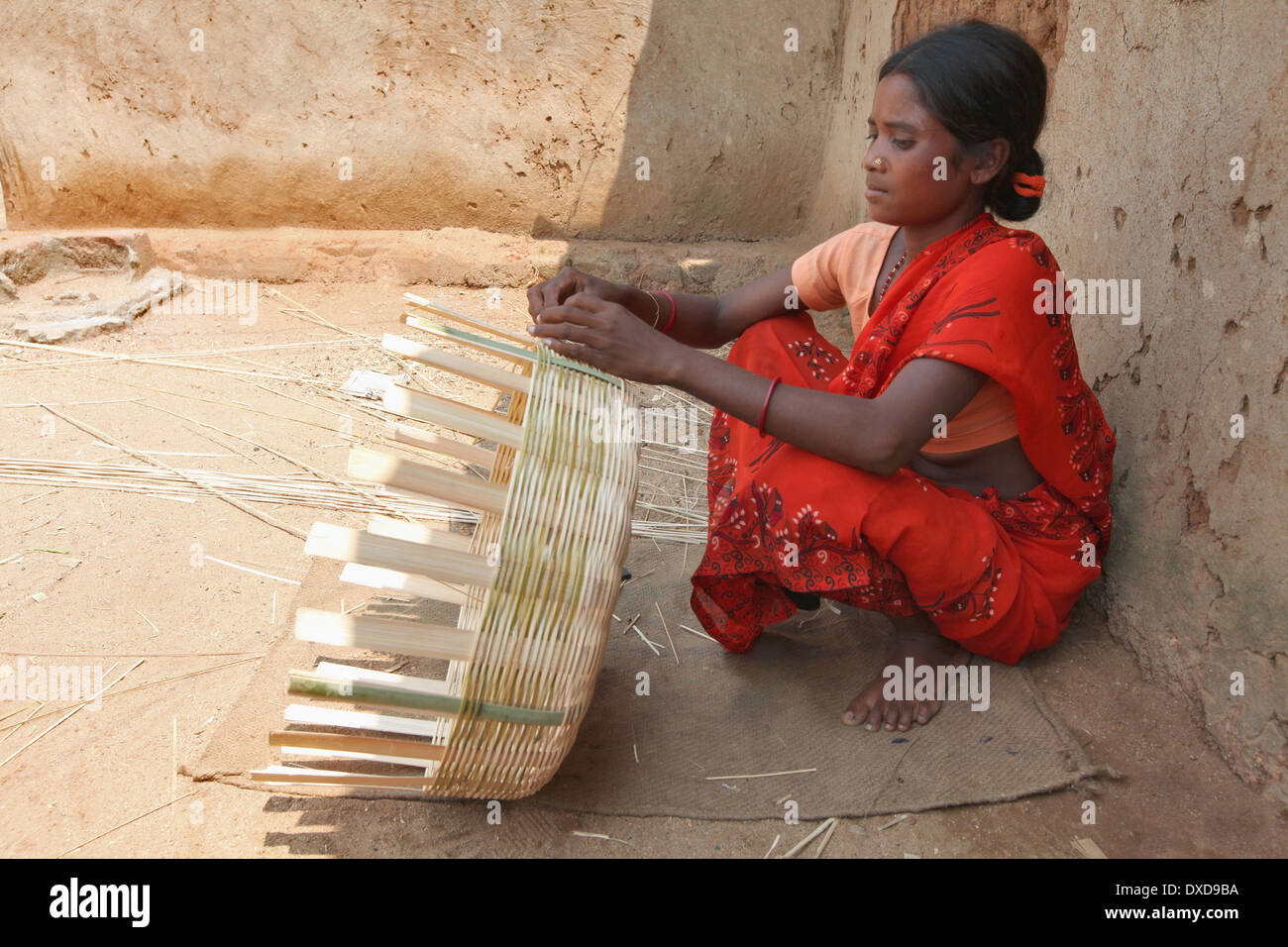 Tribal woman making baskets with dry bamboo strips. Uraov tribe ...