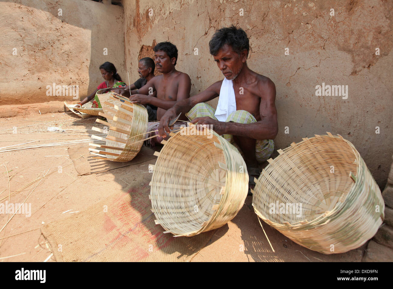 Tribal artisans making baskets with dry bamboo strips. Uraov tribe ...