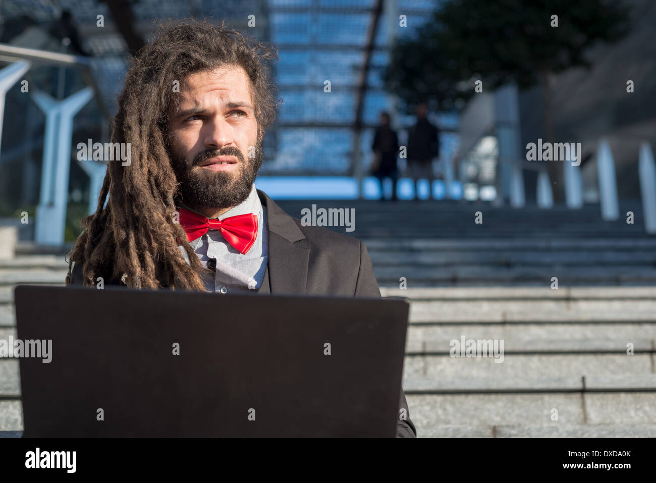 Stylish elegant dreadlocks businessman using notebook in business ...