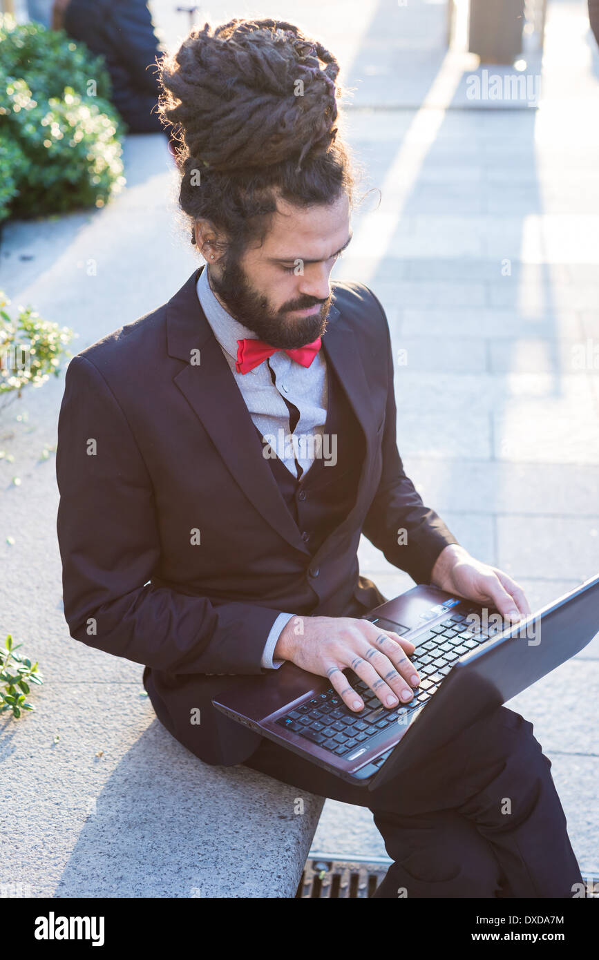 Stylish elegant dreadlocks businessman using notebook in business ...