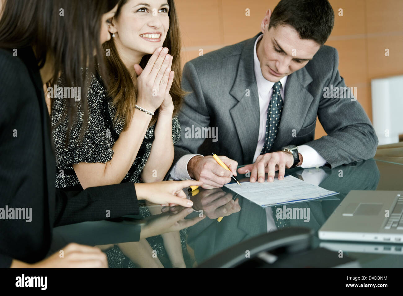 Young man signing document, professional woman pointing Stock Photo - Alamy