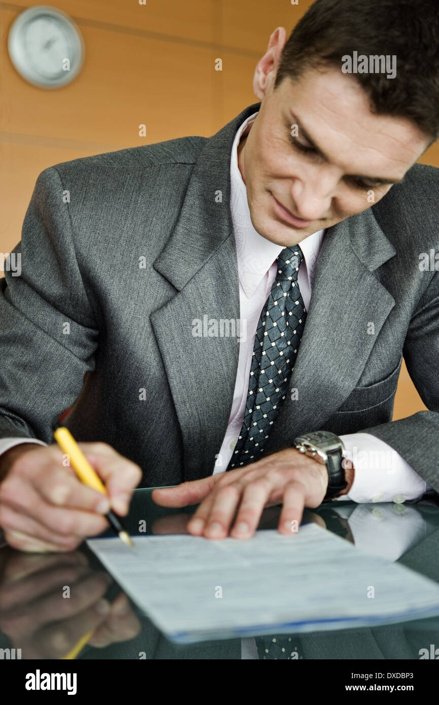 Young man signing document Stock Photo - Alamy