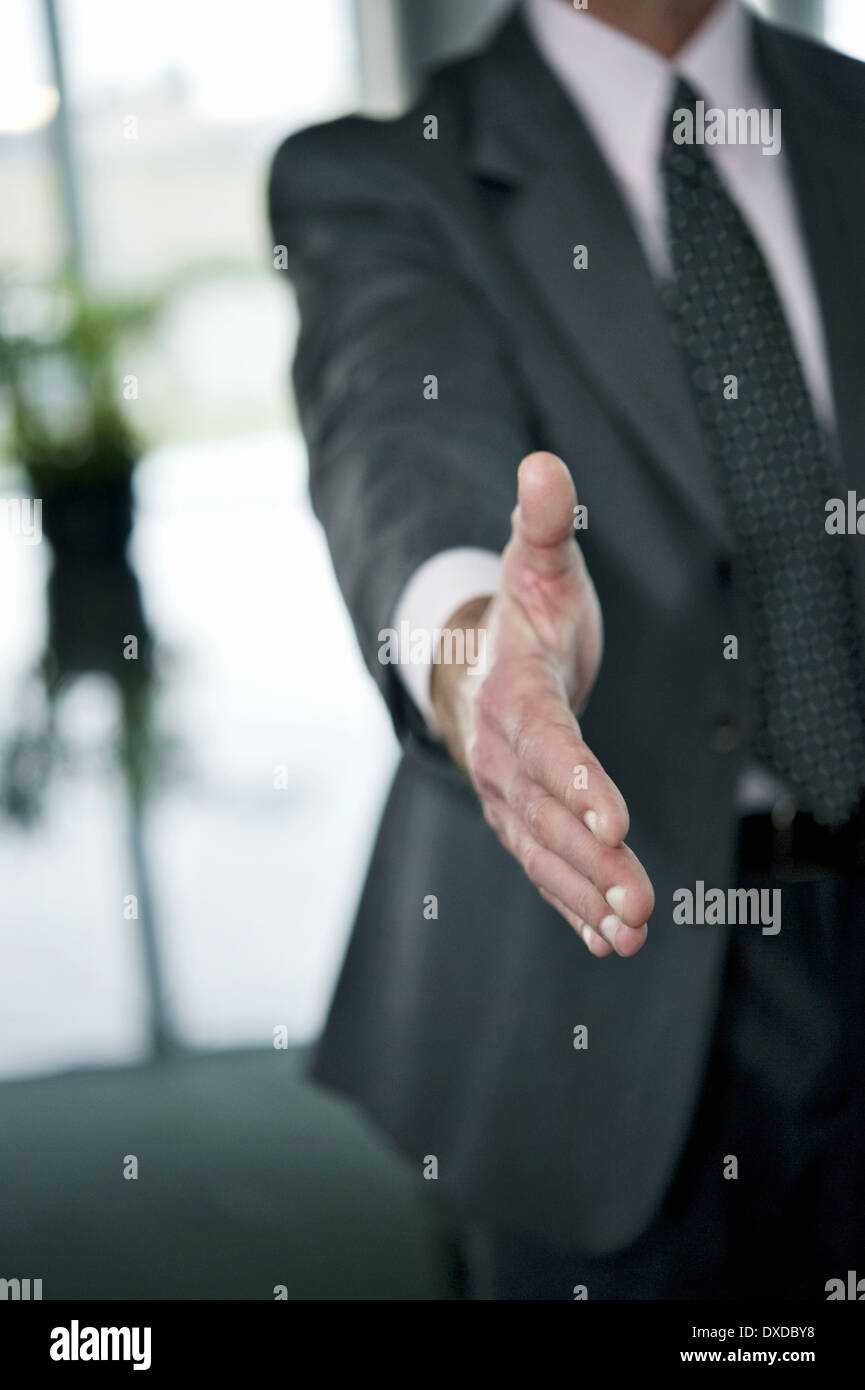 Businessman's hand out for handshake Stock Photo - Alamy