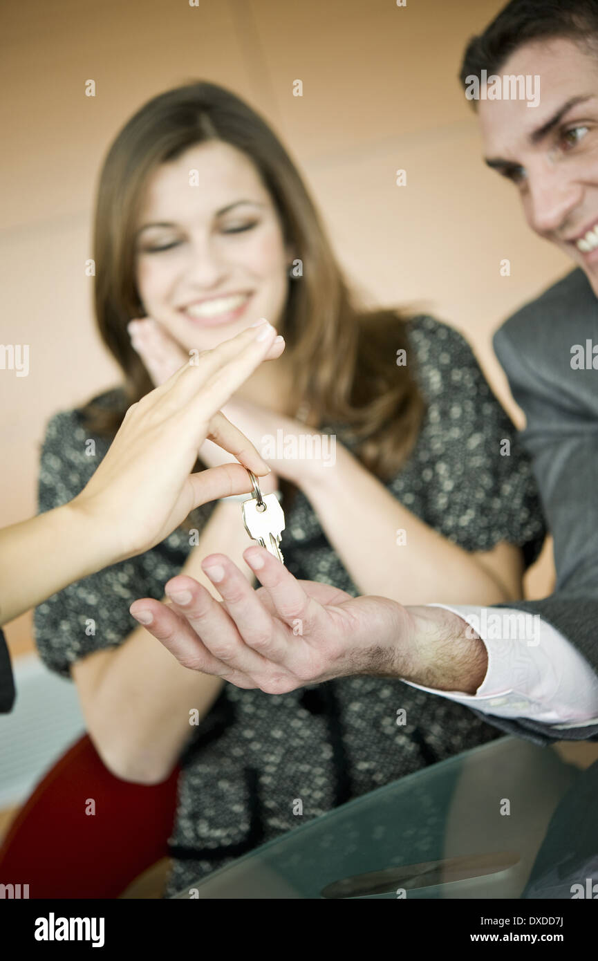 Couple receiving keys from female hand Stock Photo - Alamy