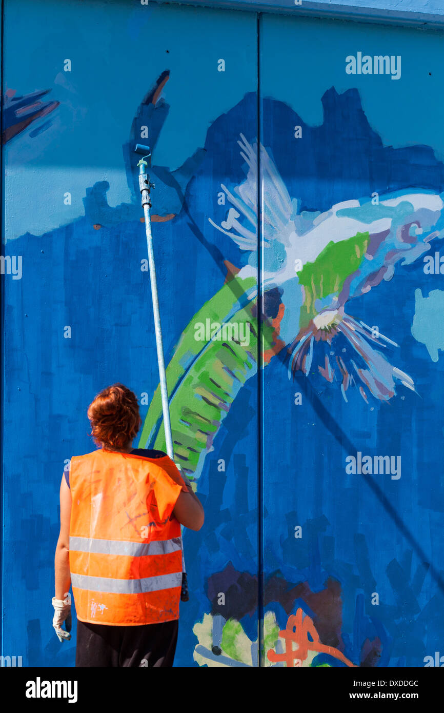 Art students painting a mural on the harbor wall at Los Cristianos ...