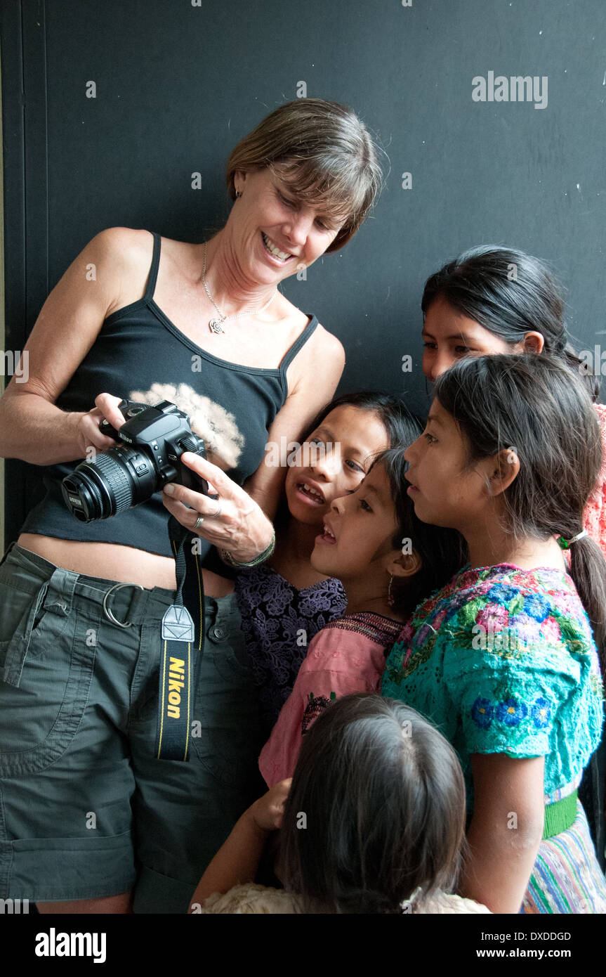 Caucasian Foreigner showing digital photographs to Mayan kids ...