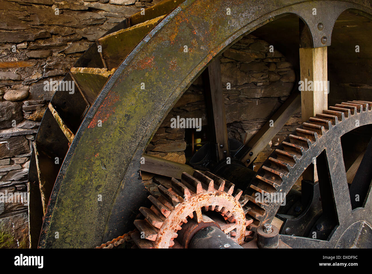 Enclosed water mill wheel workings with ancient metal and wooden cog ...