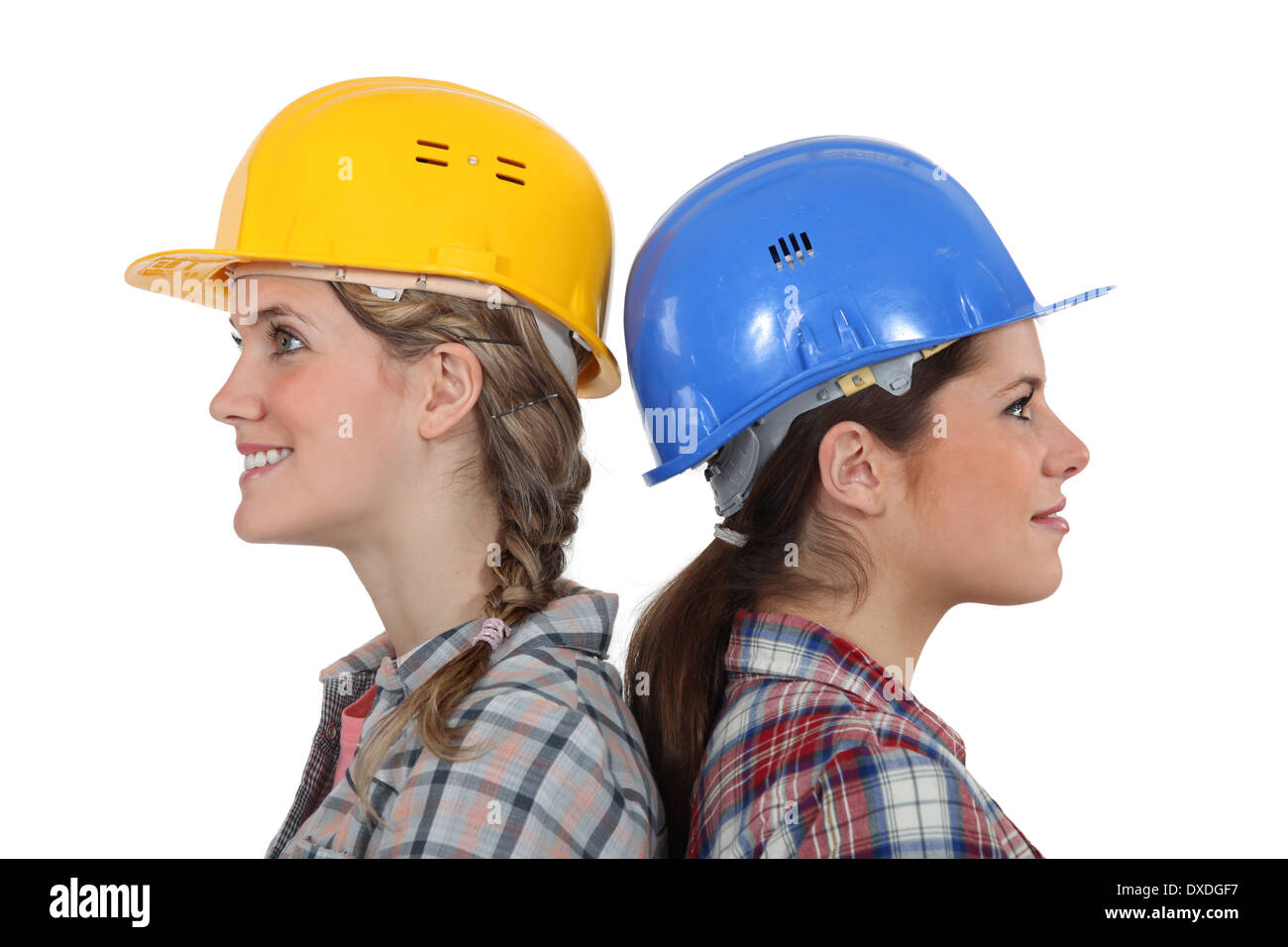 Two female builders standing back to back Stock Photo - Alamy