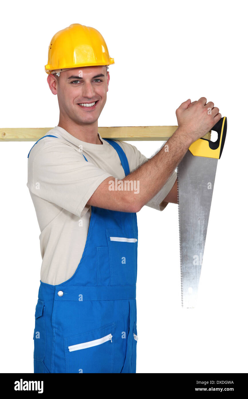 Workman carrying timber and a saw Stock Photo - Alamy