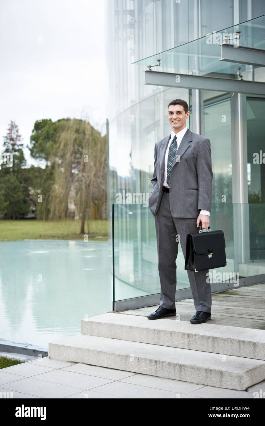 Businessman outside office building entrance Stock Photo - Alamy