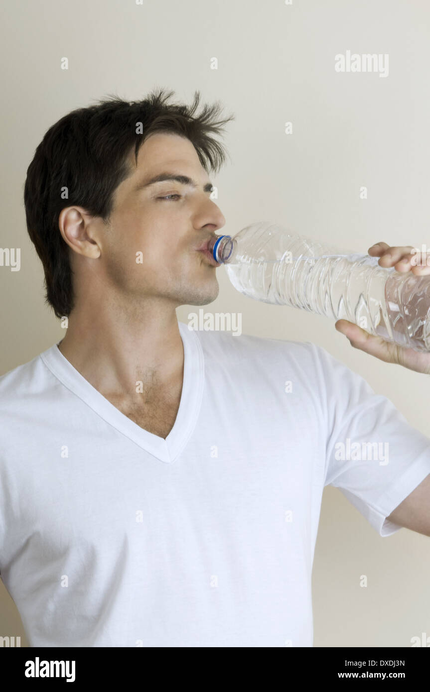Young man drinking bottled water Stock Photo - Alamy