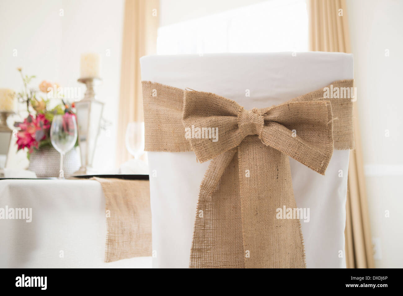 Back view of covered chair with sash and table setting for fine dining ...
