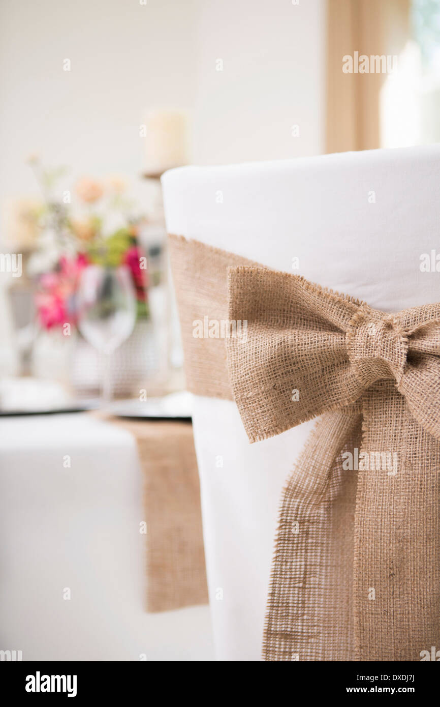 Back view of covered chair with sash and table setting for fine dining ...