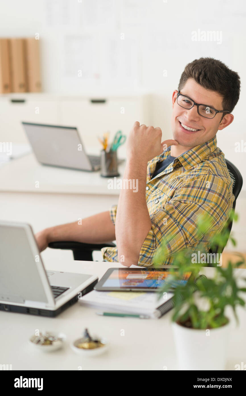 Smiling man at desk in office 20 25 years hi-res stock photography and ...