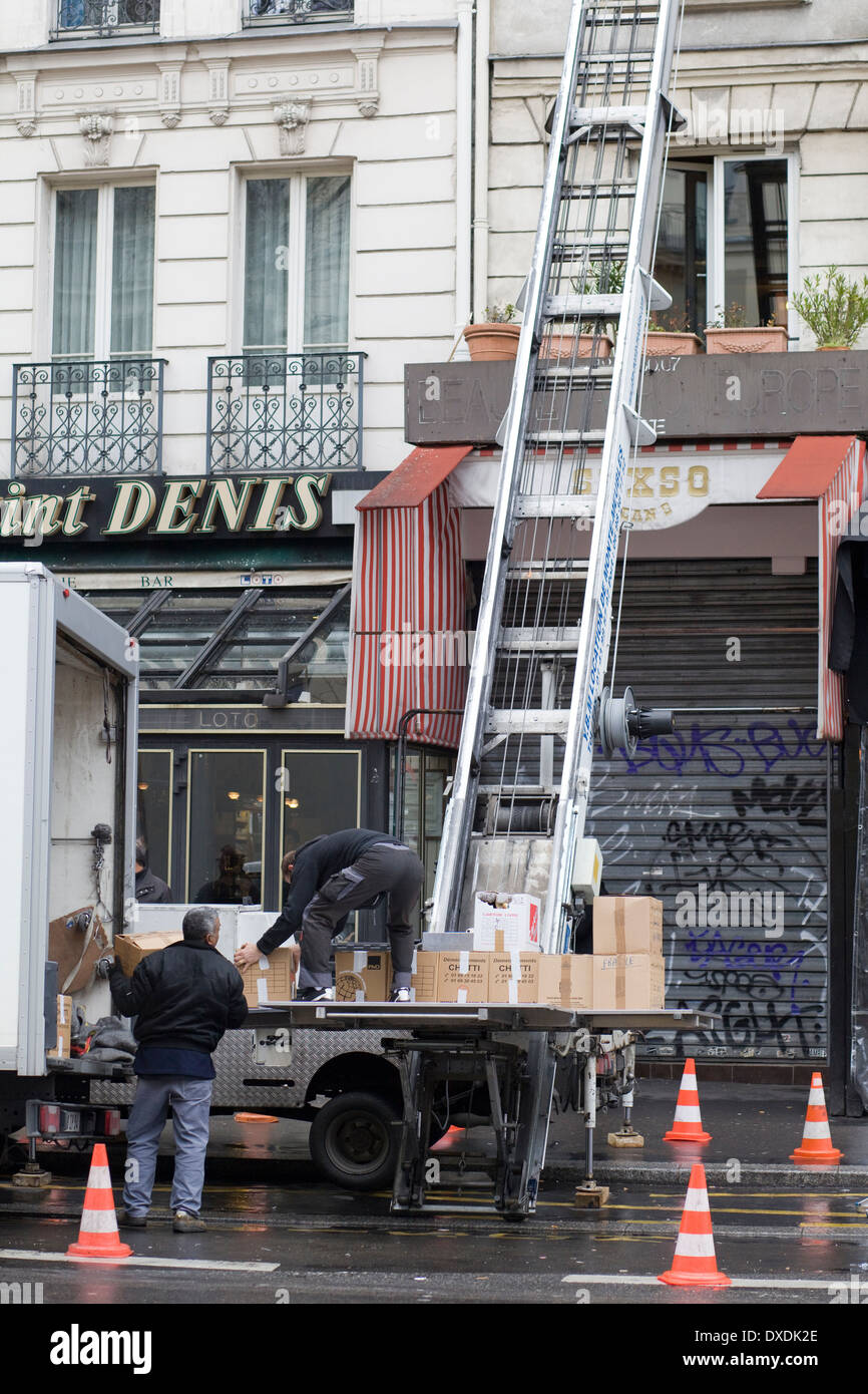 mechanical ladder lifting equipment moving boxes to upper window Stock ...